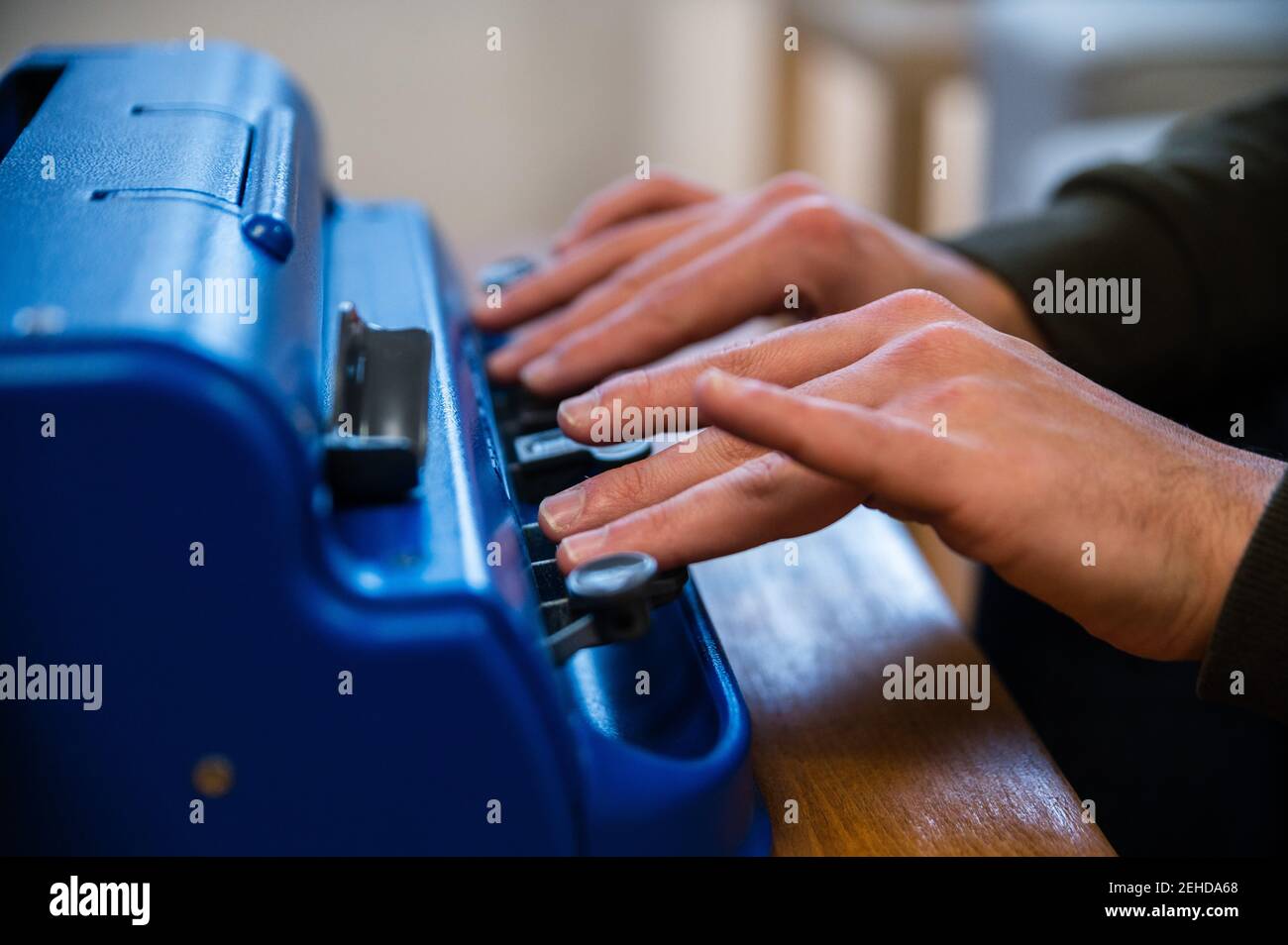 Crop anonymous visually impaired male typing on typewriter with tactile ...