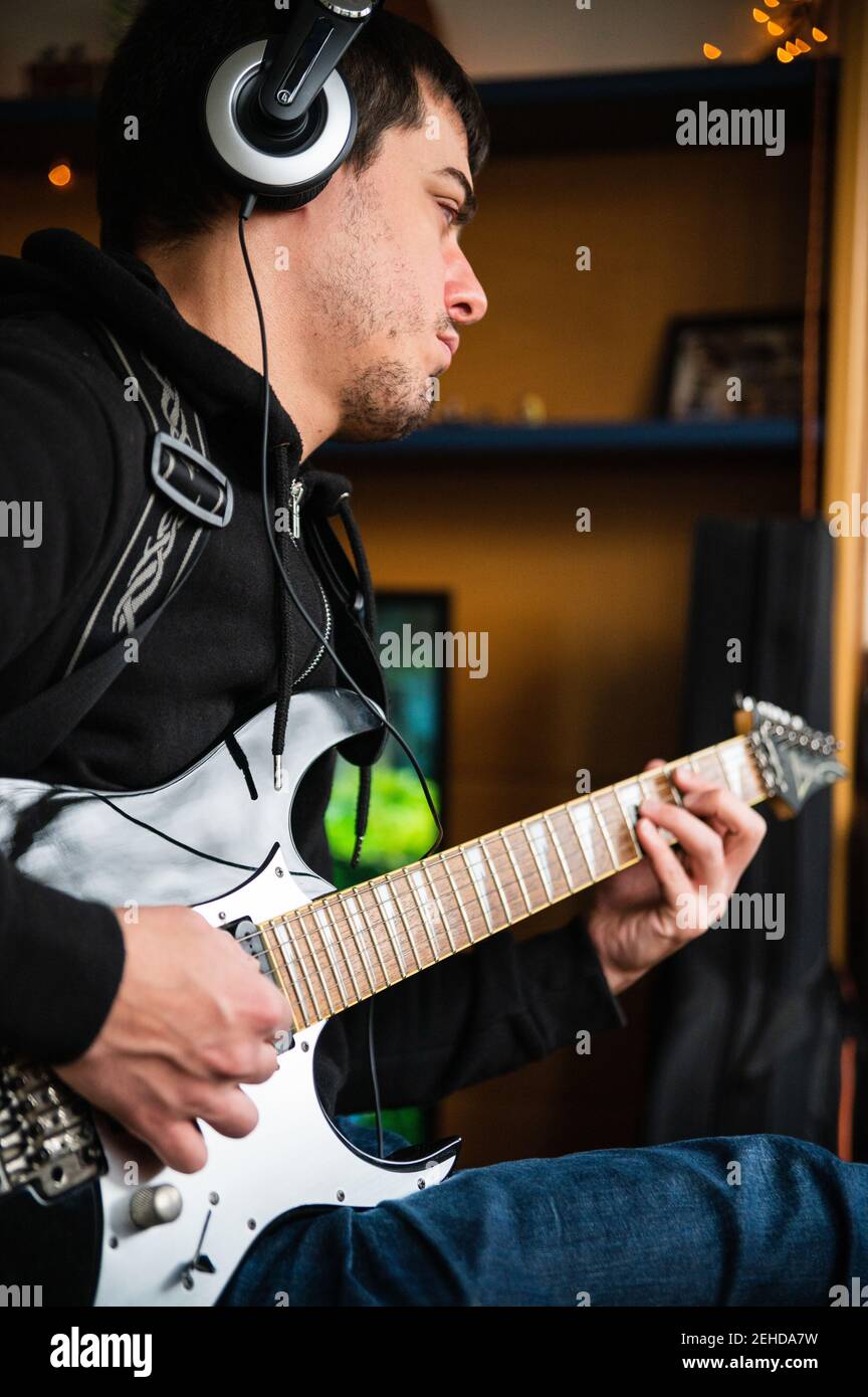 Low angle side view of concentrated blind guitarist playing music ...