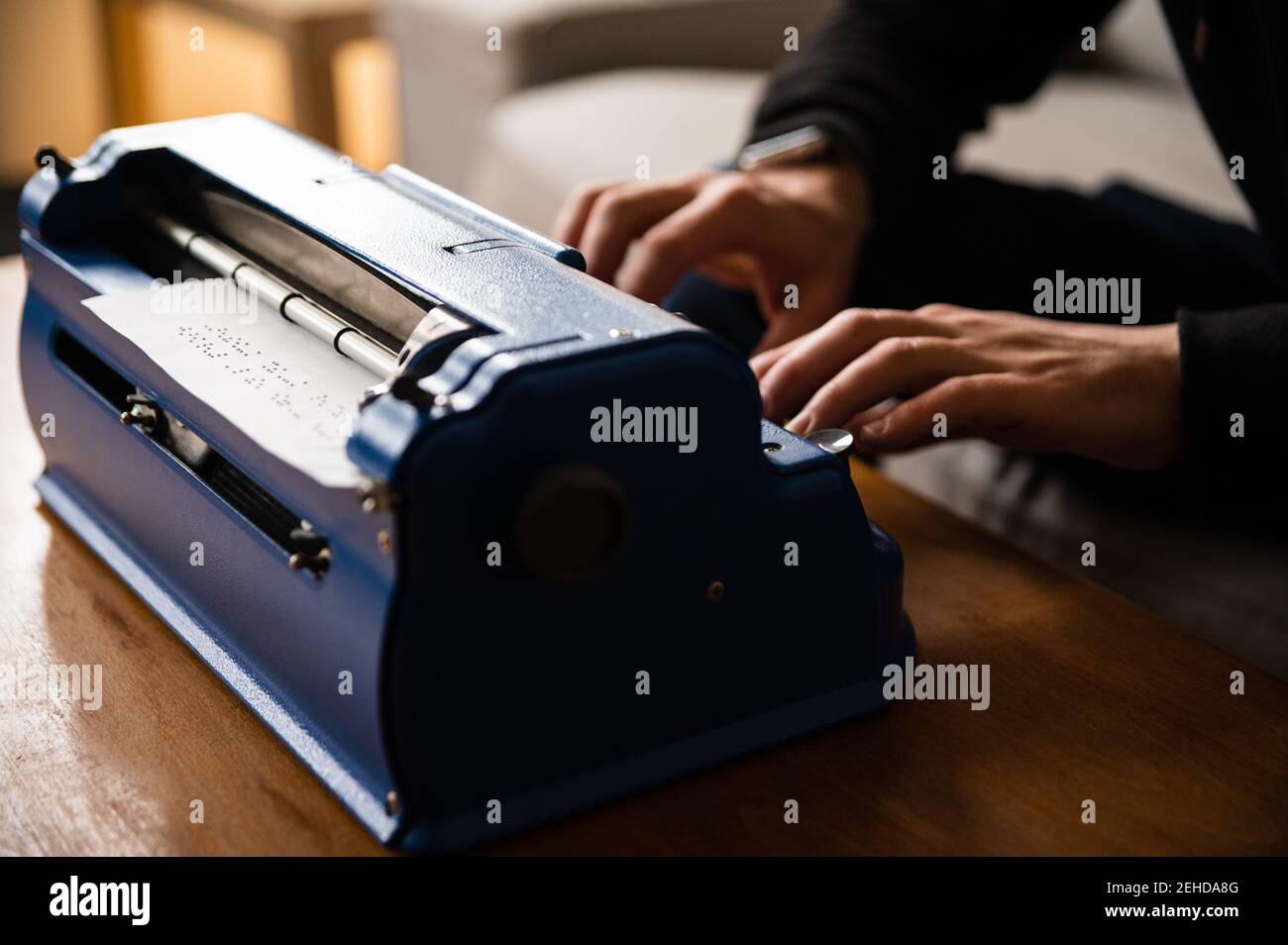 Crop anonymous visually impaired male typing on typewriter with tactile ...