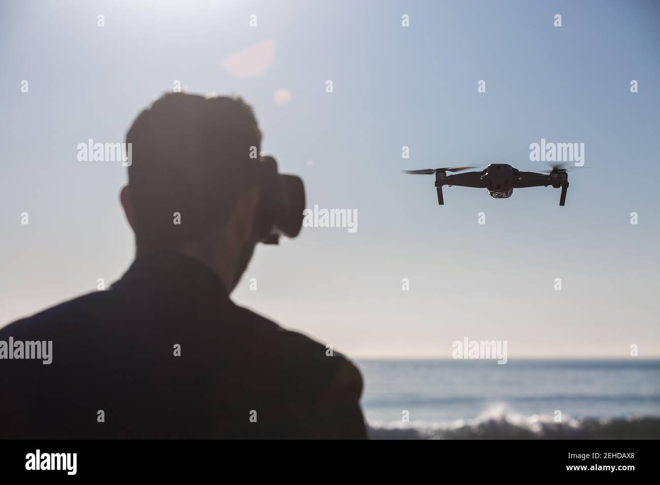 Back view of unrecognizable male wearing modern VR goggles operating ...