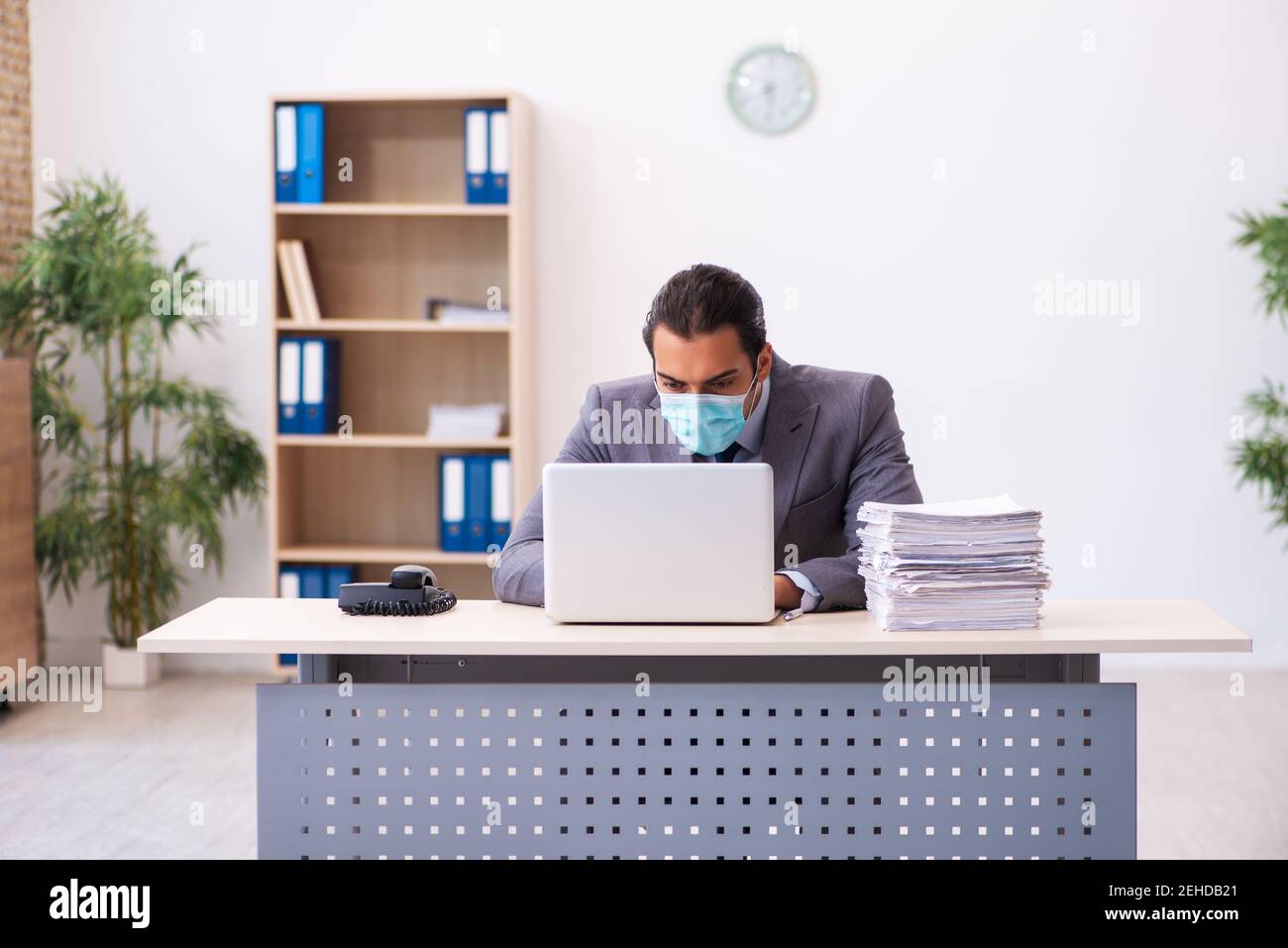 Young employee wearing mask during pandemic Stock Photo - Alamy