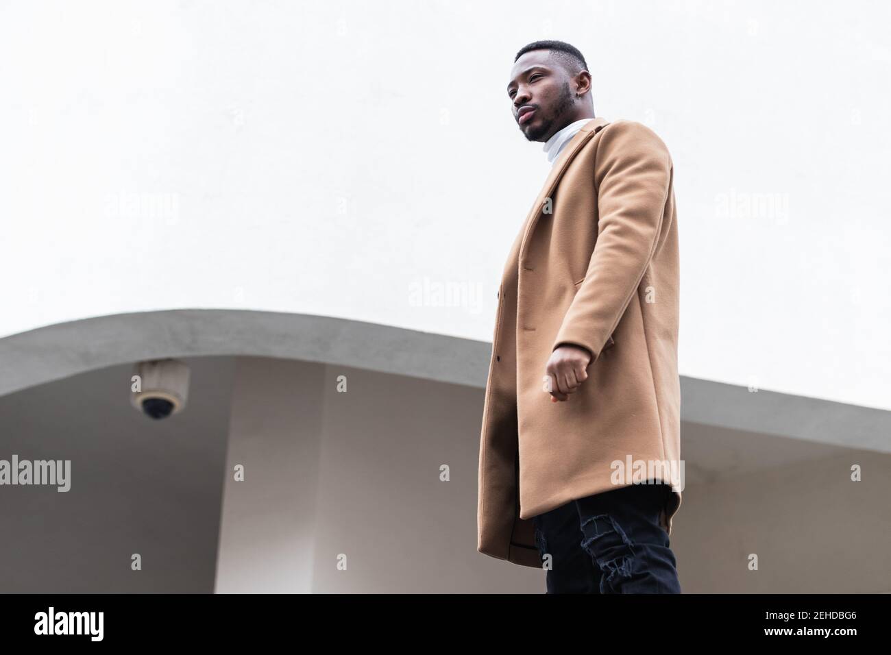 From below side view of unemotional young dreamy African American male ...