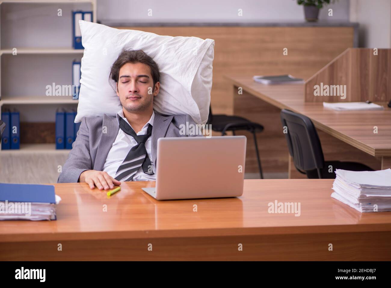 Young employee sleeping at workplace Stock Photo - Alamy
