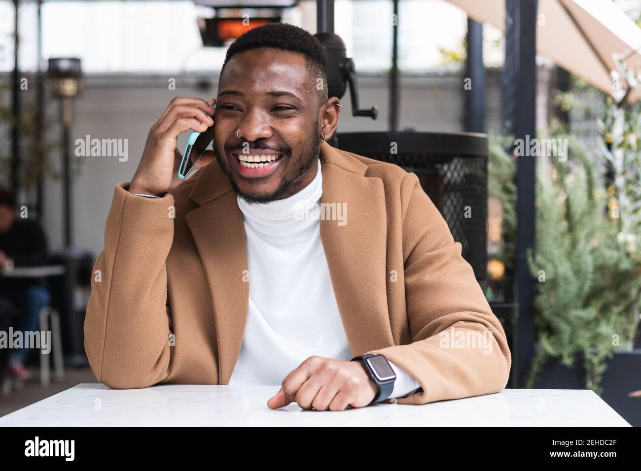 Through fence hole view of young glad African American male with ...