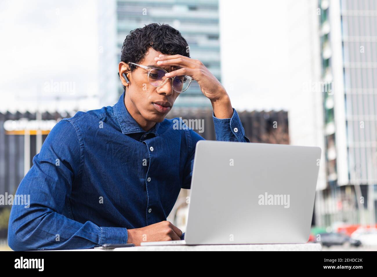 Happy young African American female with curly hair wearing blue coat ...