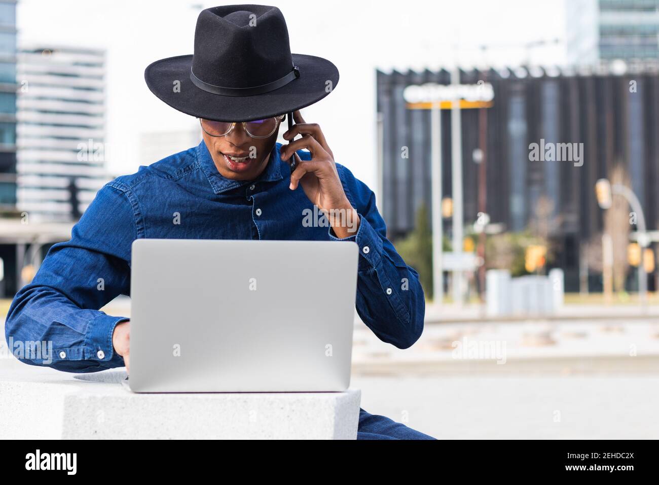 Stylish adult concentrated ethnic male remote employee with hat having ...