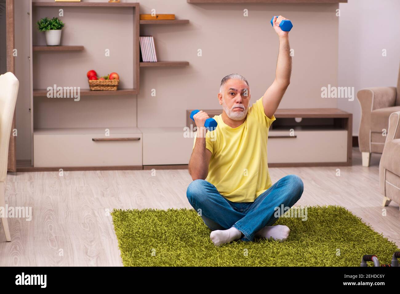 Old man doing sport exercises at home Stock Photo - Alamy