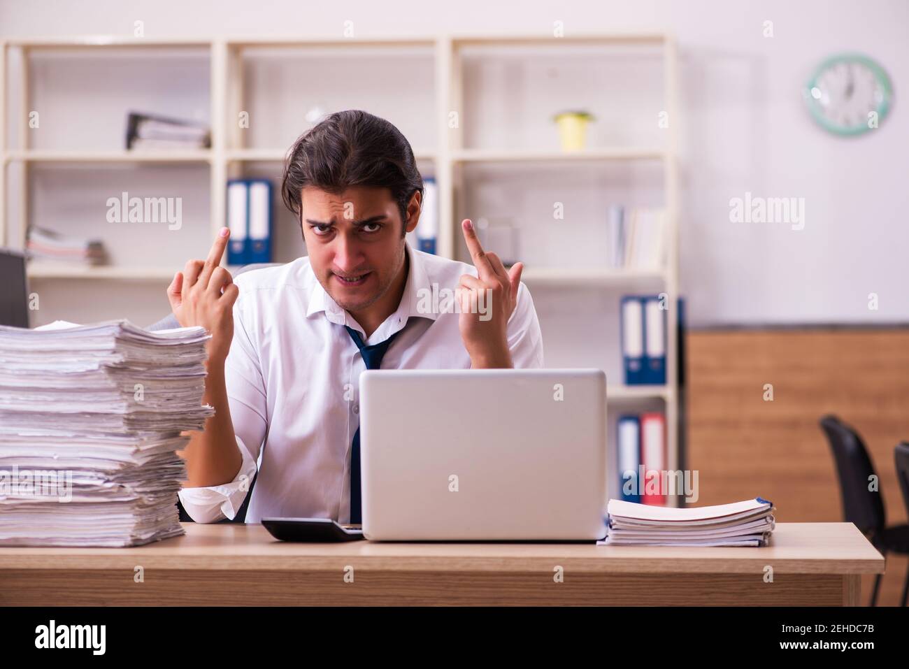 Male employee unhappy with excessive work in the office Stock Photo - Alamy