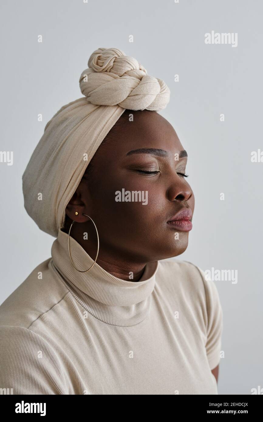 Gorgeous young African female model in stylish traditional turban ...