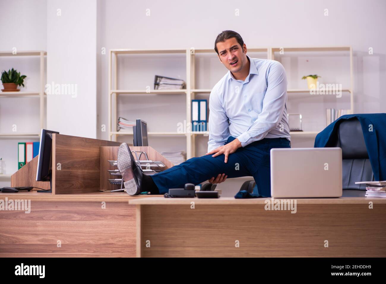 Young employee doing physical exercises at workplace Stock Photo - Alamy
