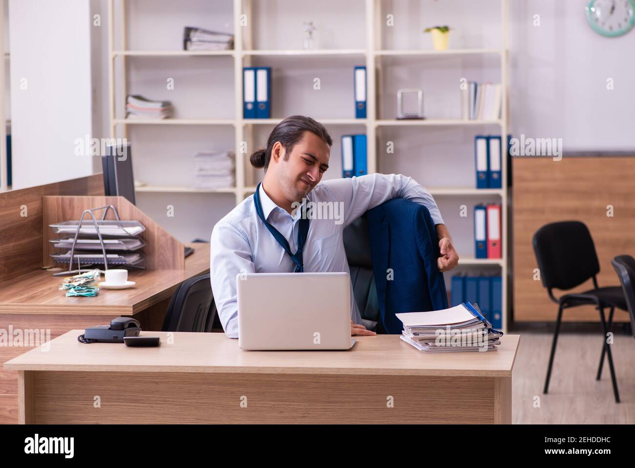 Young employee stretching at workplace Stock Photo - Alamy