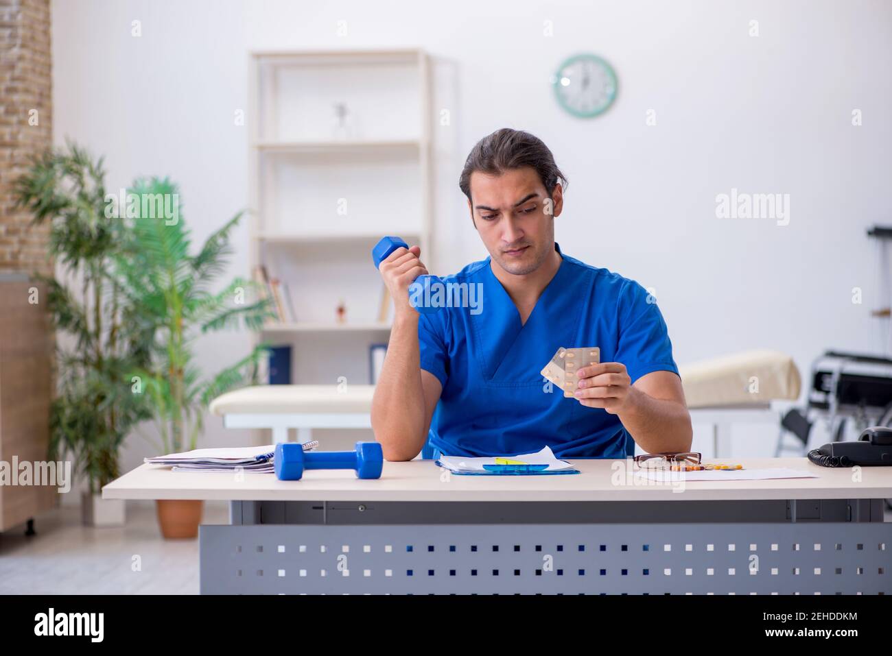 Young doctor physiotherapist doing sport exercises Stock Photo - Alamy
