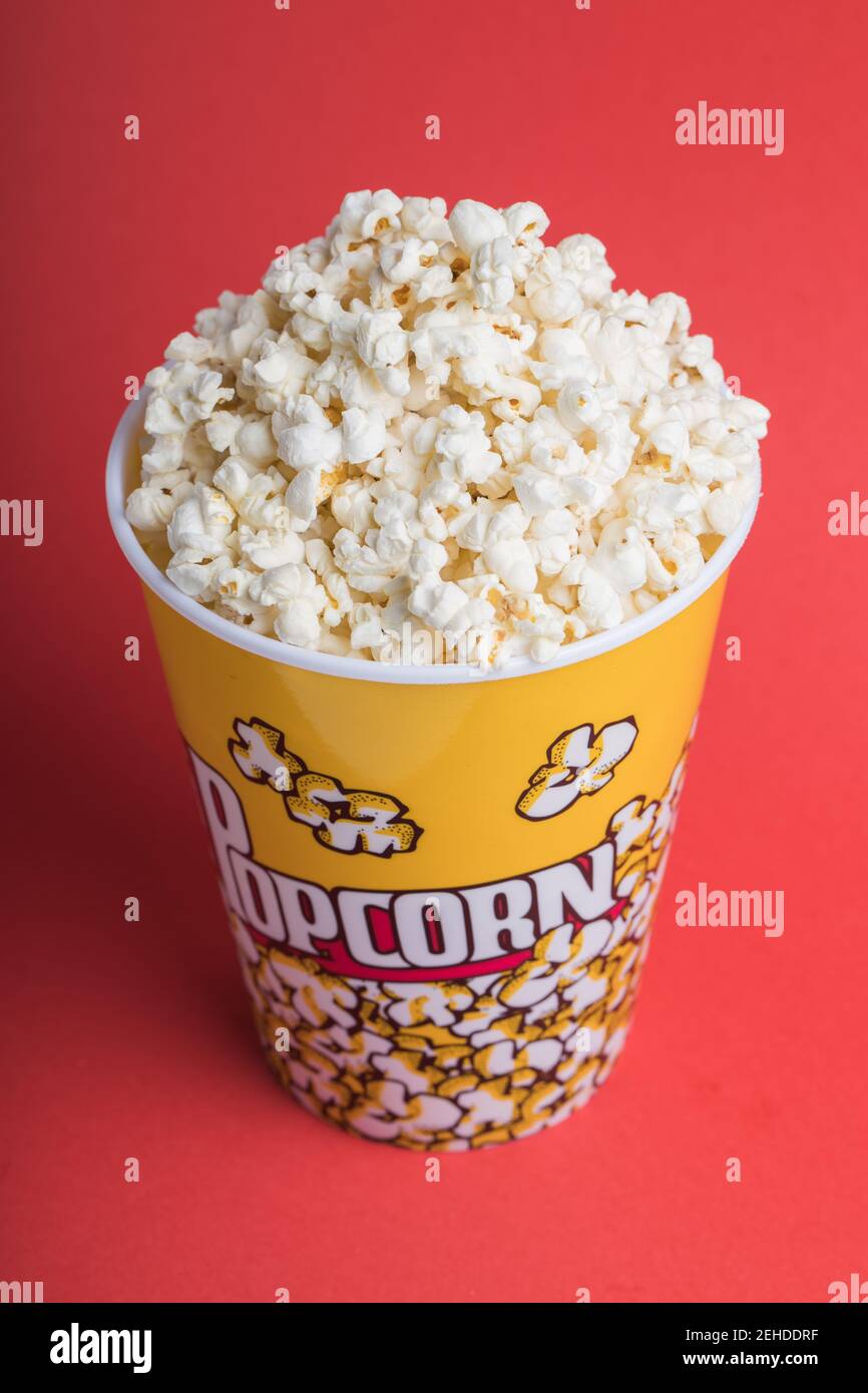 Top view bowl full of popcorn on a red background Stock Photo - Alamy