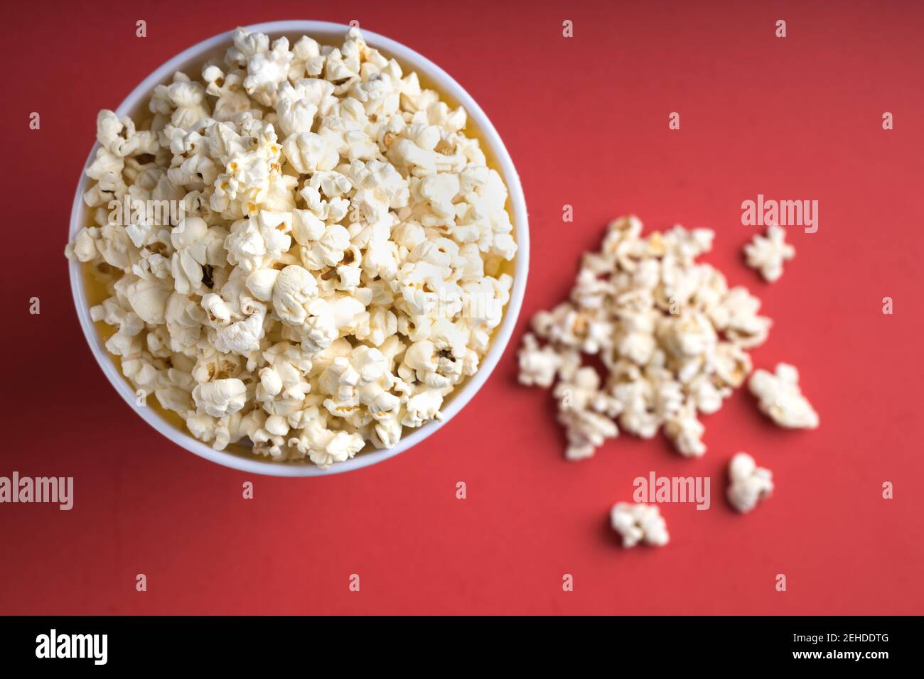Top view bowl full of popcorn on a red background Stock Photo - Alamy