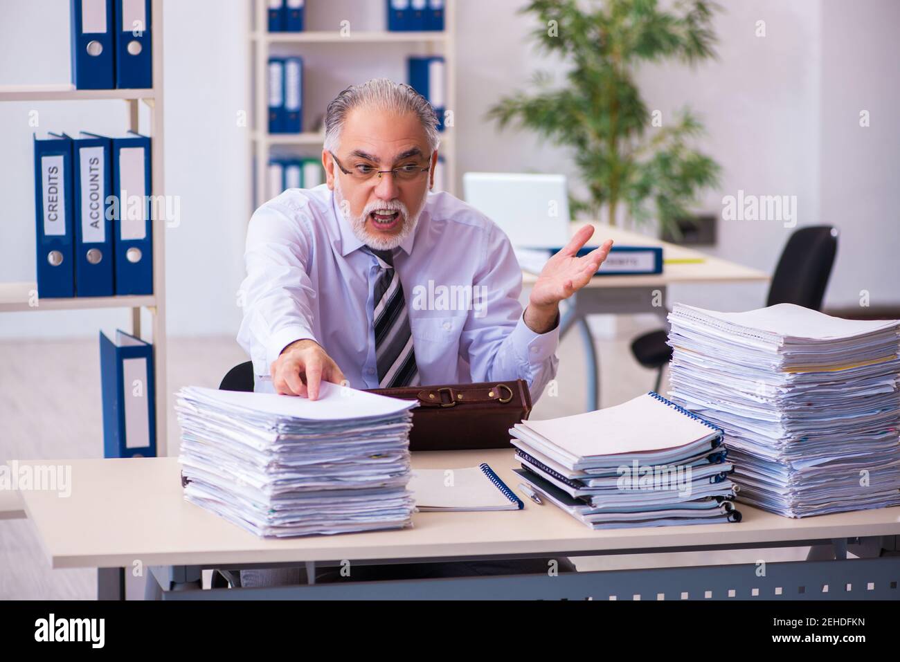 Old employee unhappy with excessive work in the office Stock Photo - Alamy