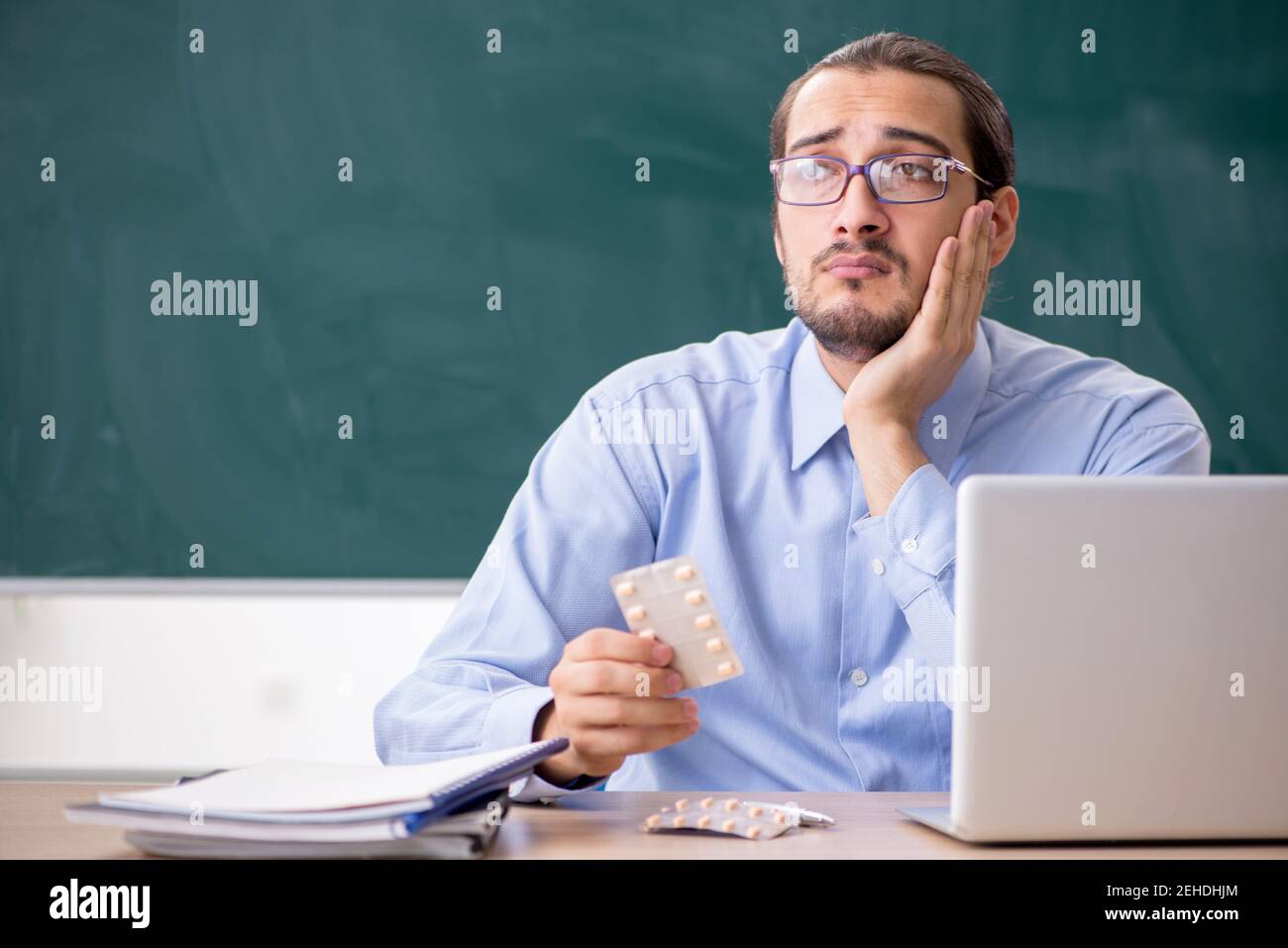 Young sick teacher in the classroom Stock Photo - Alamy
