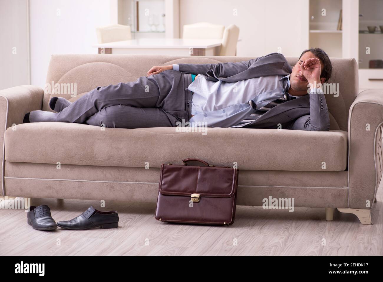 Tired businessman coming home after working day Stock Photo - Alamy