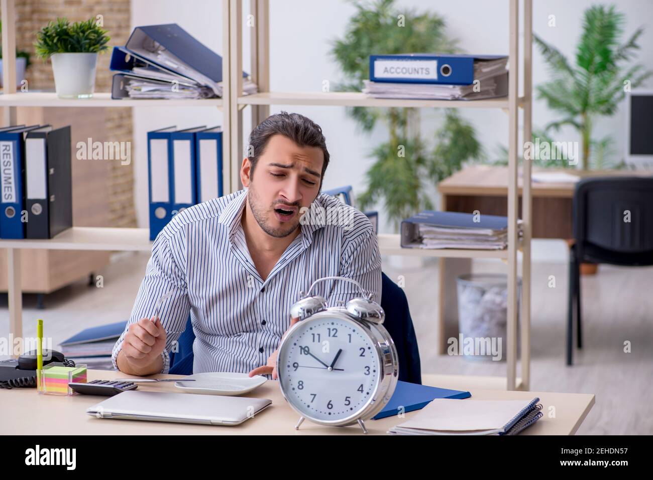 Hungry employee waiting for food in time management concept Stock Photo ...