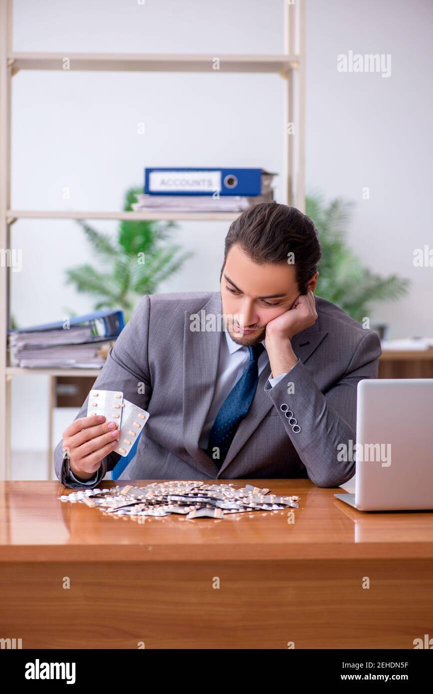 Male sick employee suffering at workplace Stock Photo - Alamy