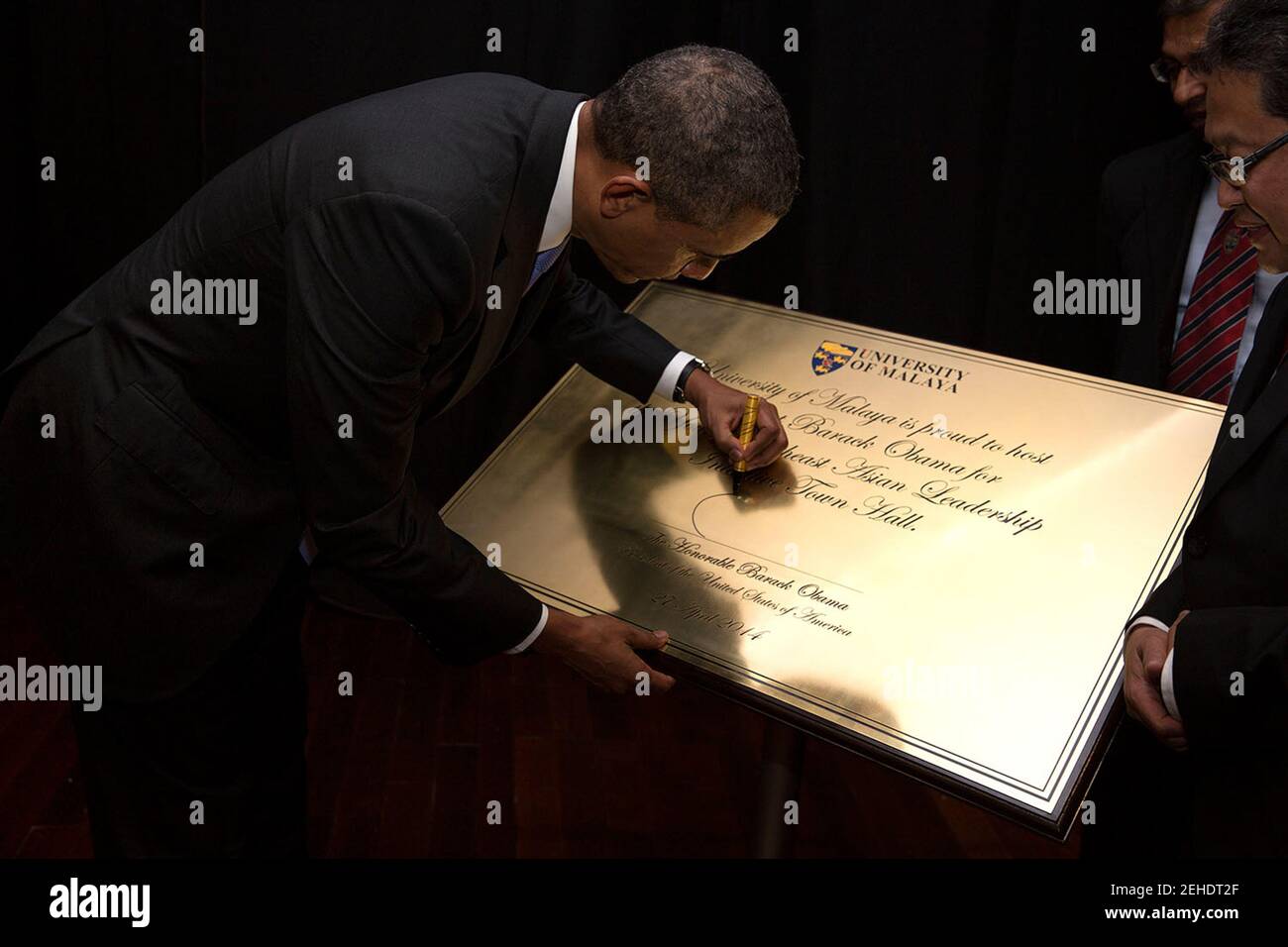 President Barack Obama signs a plaque to be engraved, at the University ...