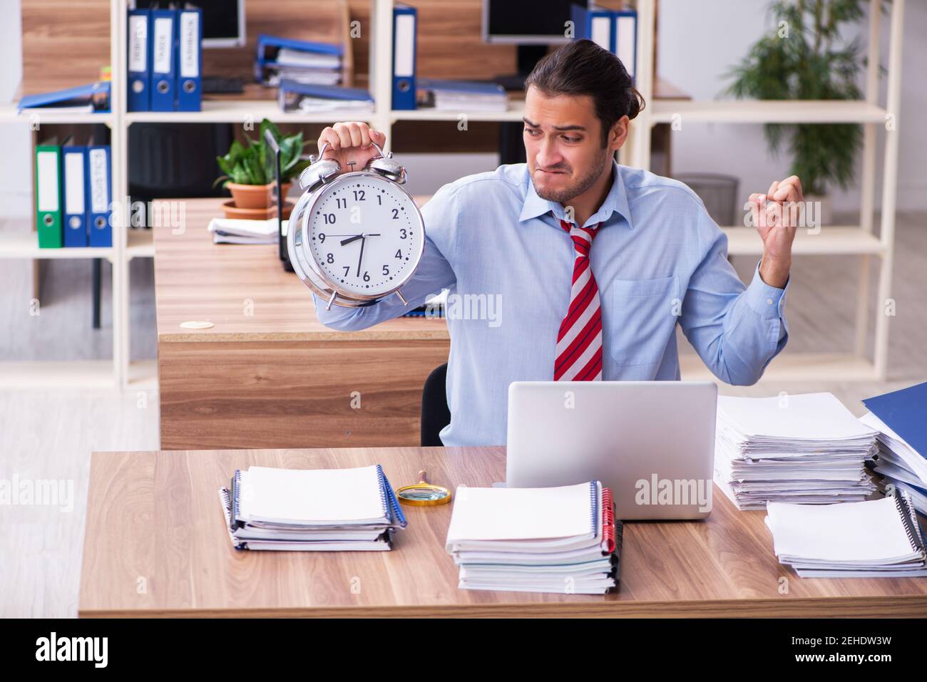 Young employee unhappy with excessive work in time management concept ...