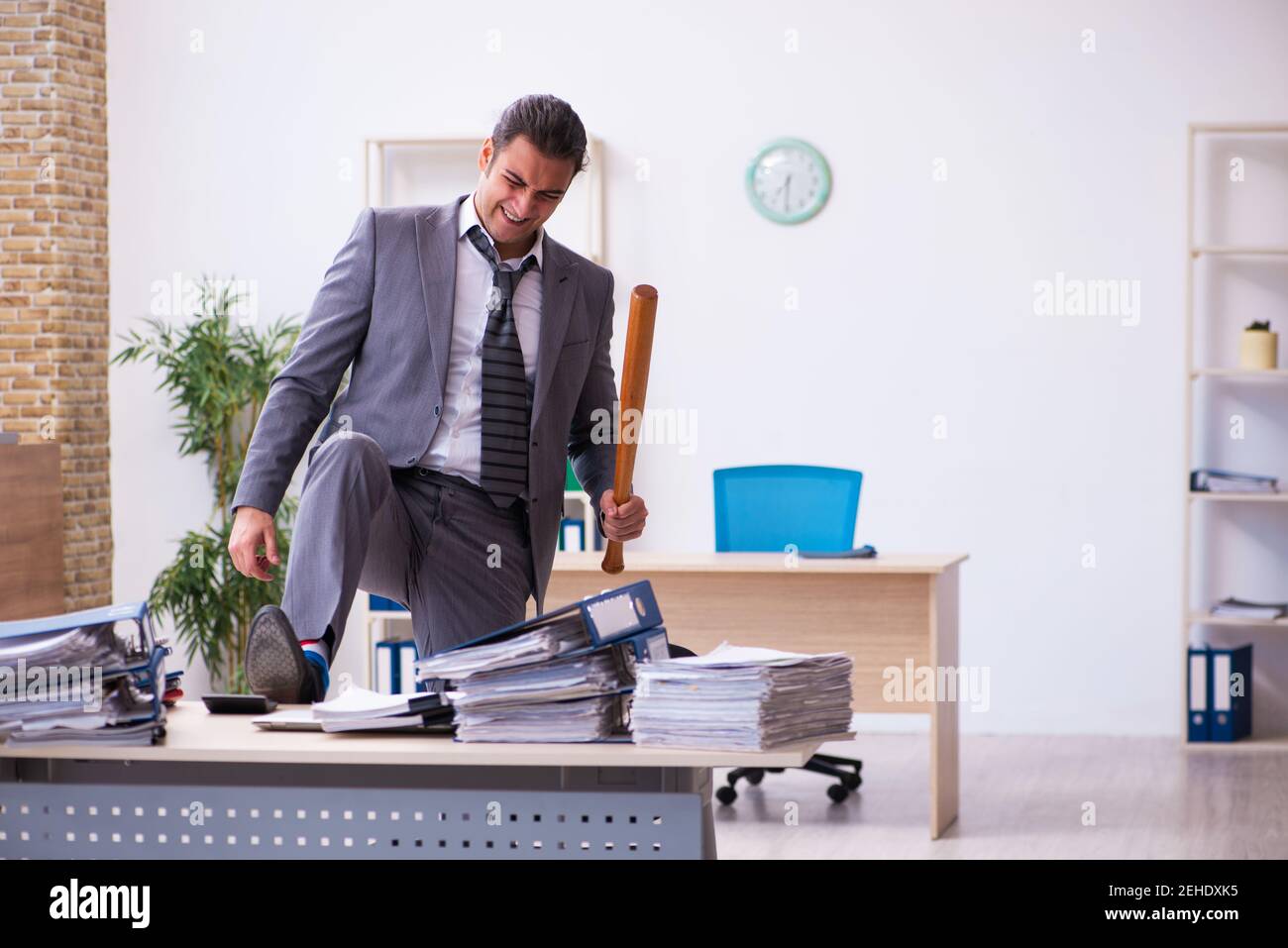 Male employee angry with excessive work holding baseball bat Stock ...