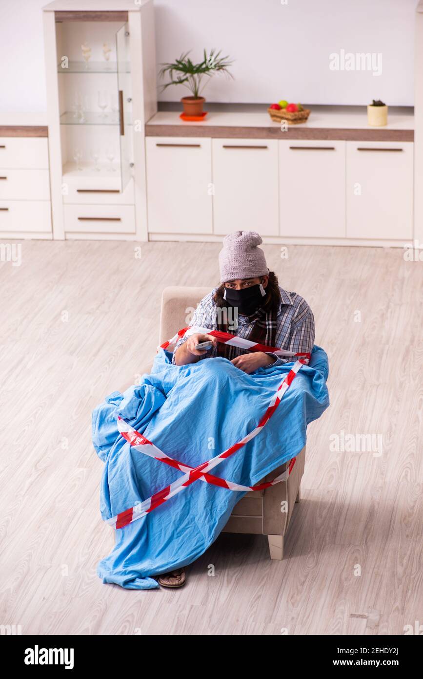 Sick man watching tv at home in pandemic concept Stock Photo - Alamy
