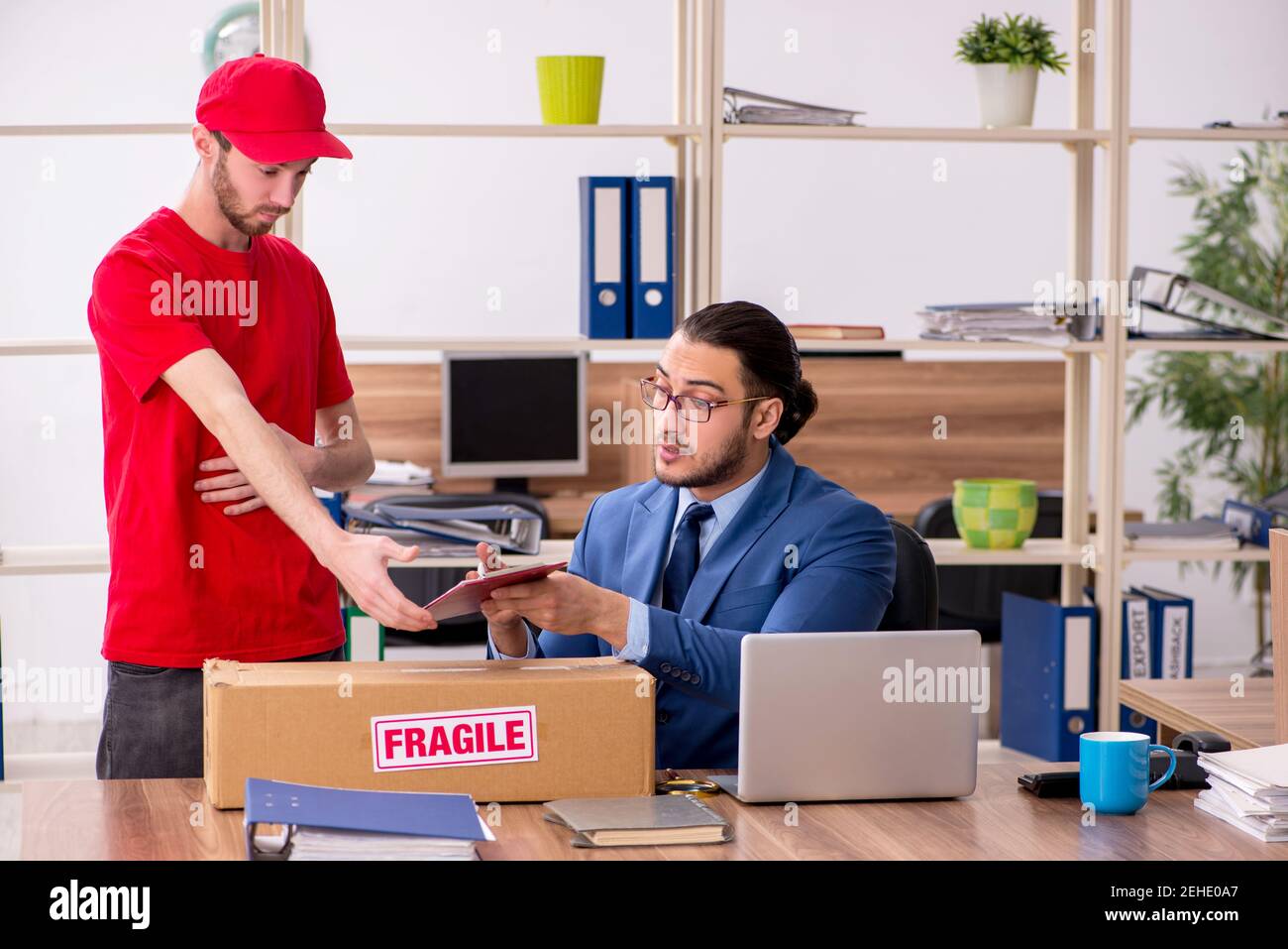 Man delivering parcel to the office Stock Photo - Alamy