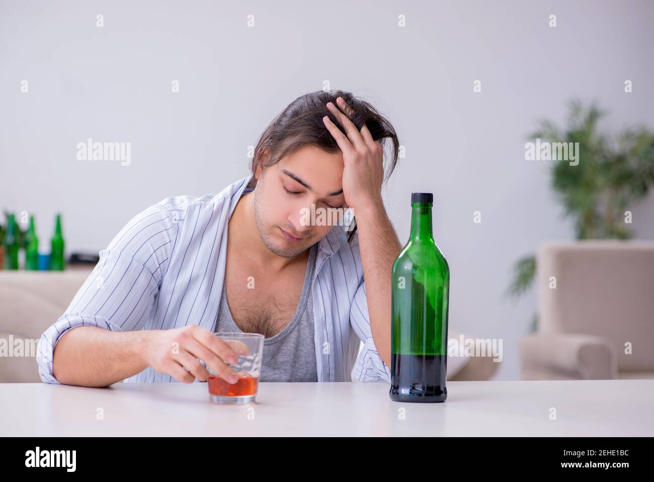 Male alcoholic drinking whiskey at home Stock Photo - Alamy