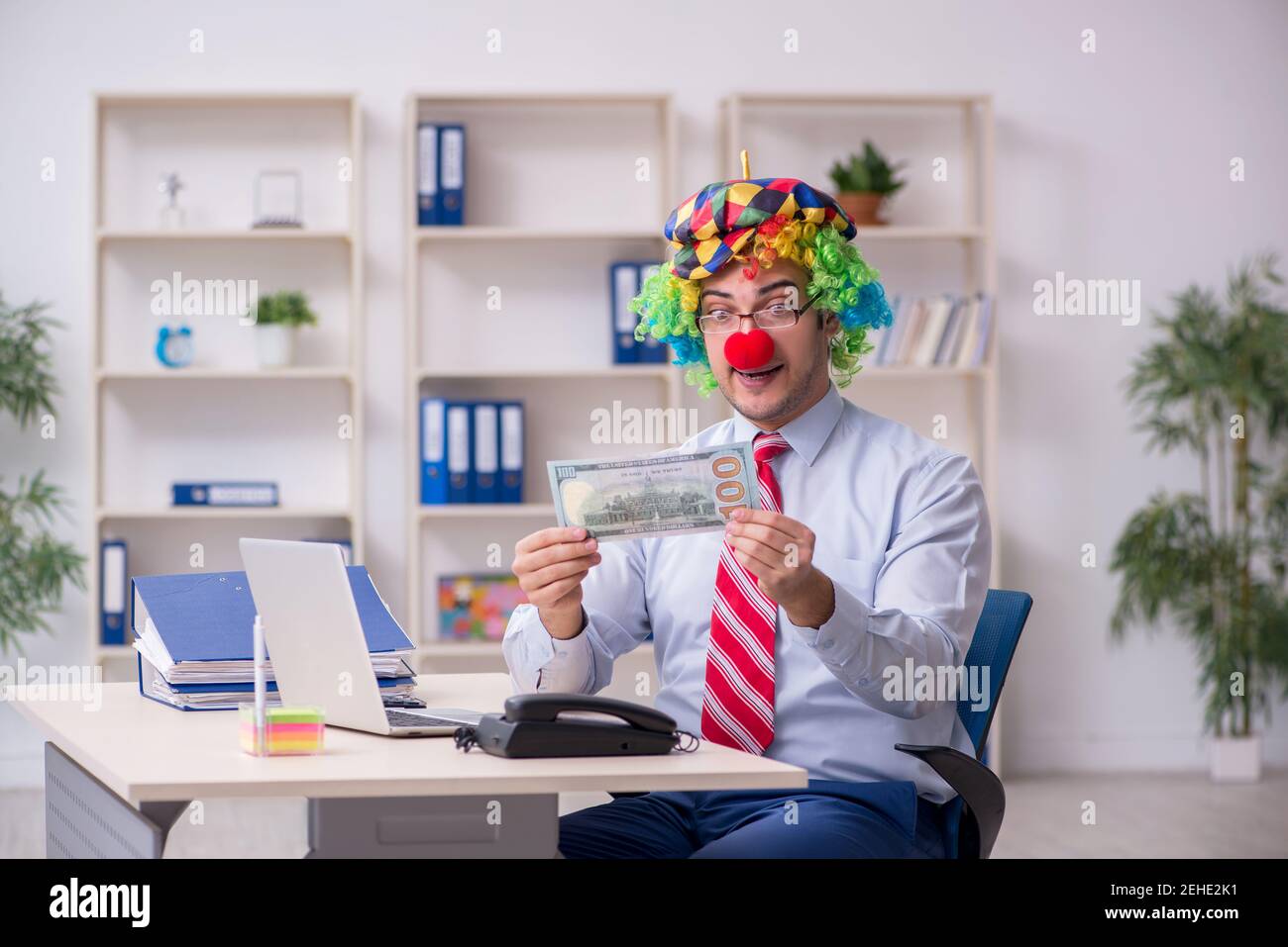 Funny employee clown working in the office room Stock Photo - Alamy