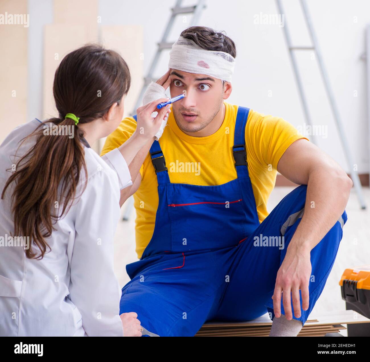 The worker with injured head and doctor Stock Photo - Alamy