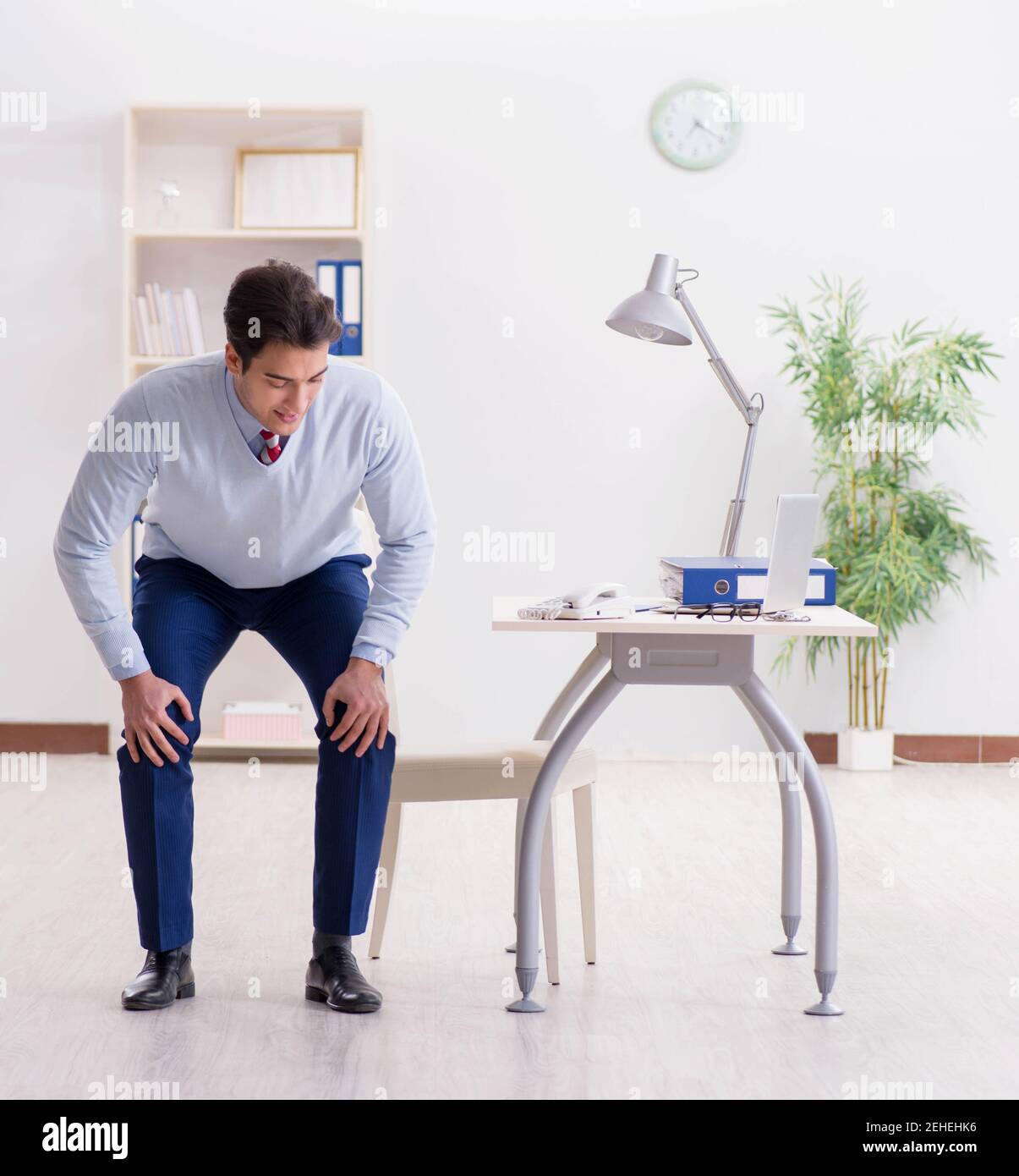 The employee suffering from backpain in office Stock Photo - Alamy