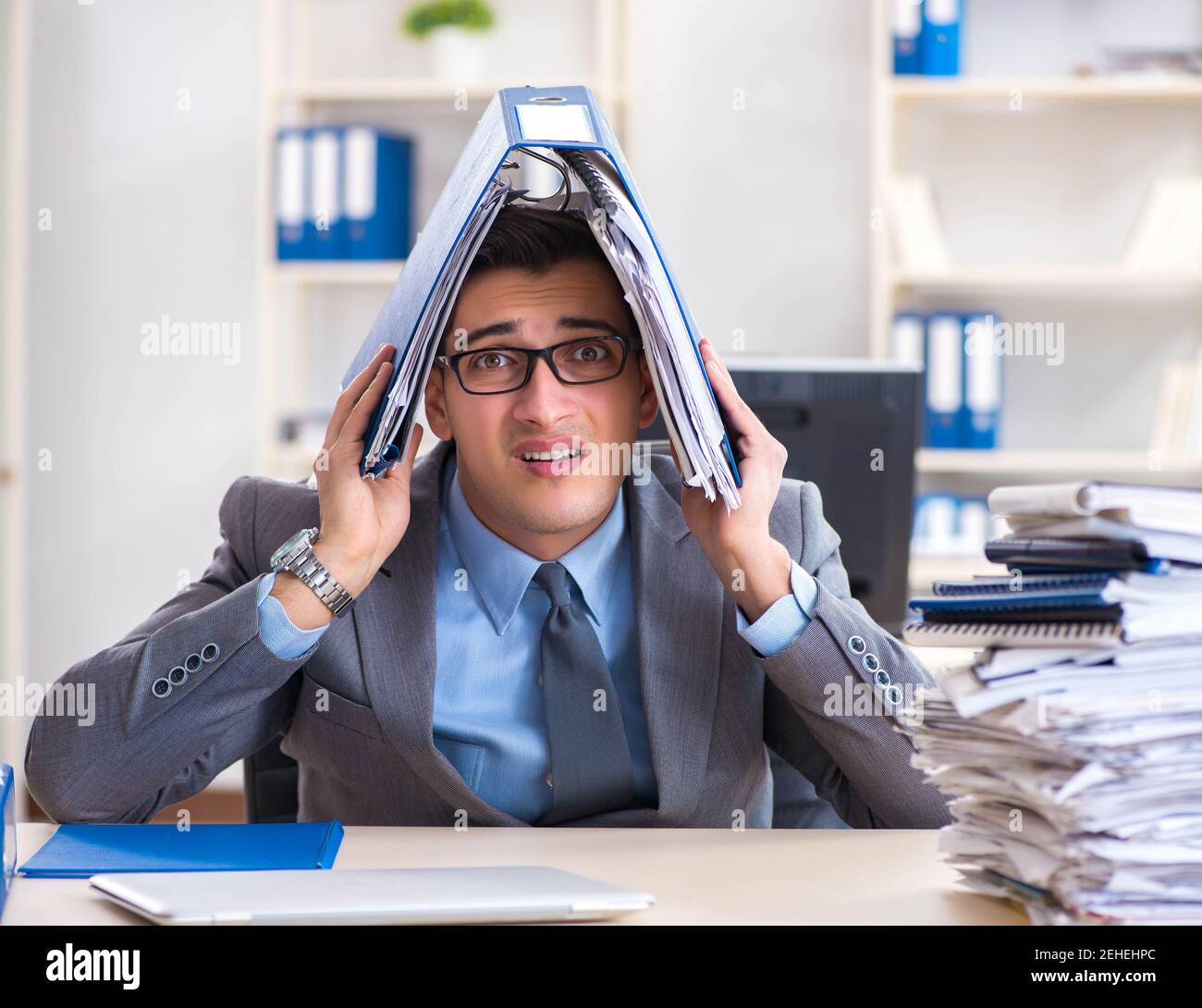 The overloaded with work employee under paperwork burden Stock Photo ...