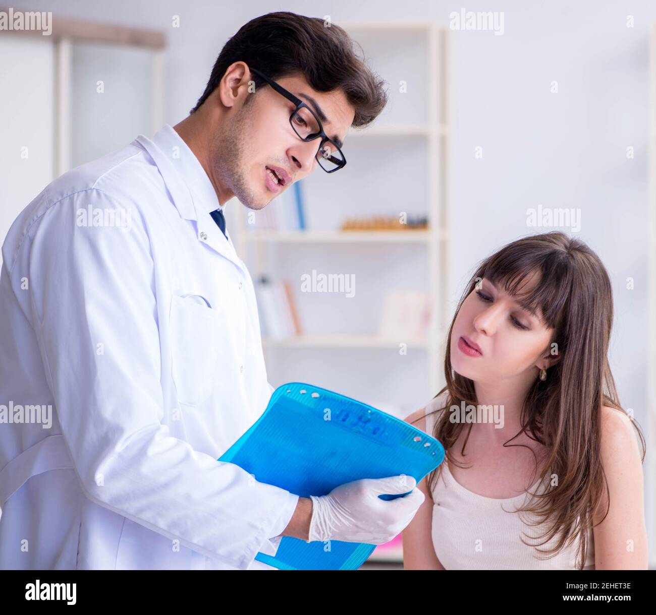 The doctor examining the skin of female patient Stock Photo - Alamy