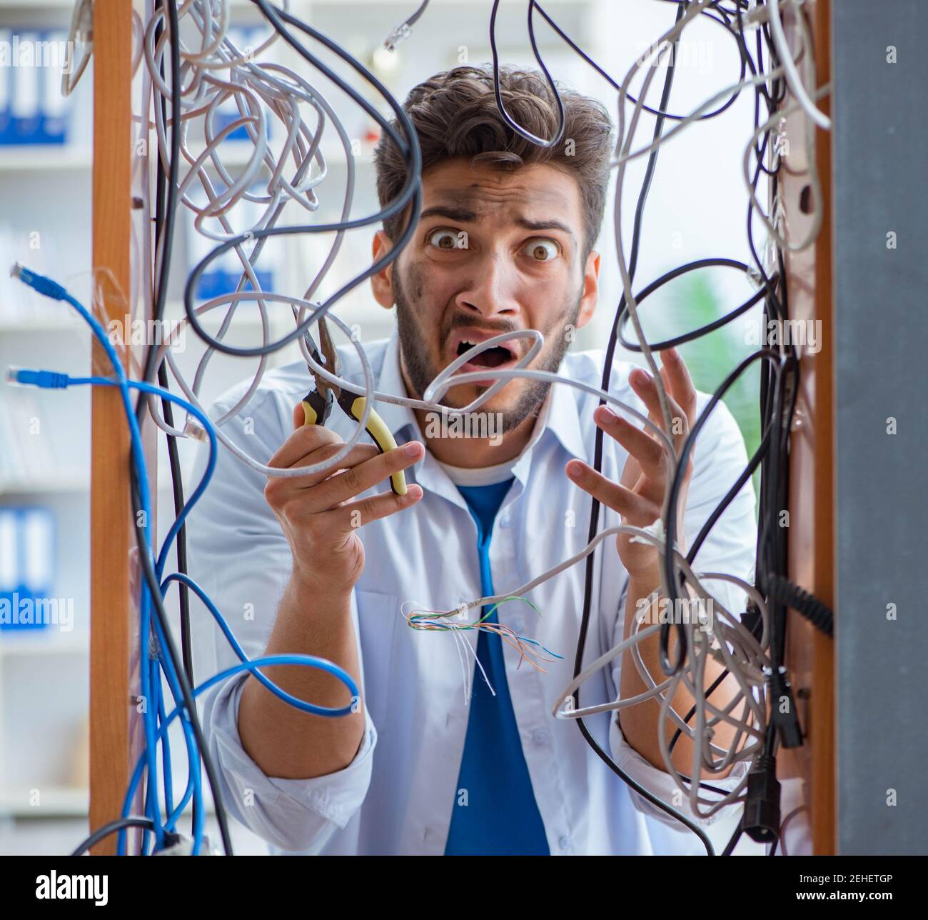 The electrician trying to untangle wires in repair concept Stock Photo ...