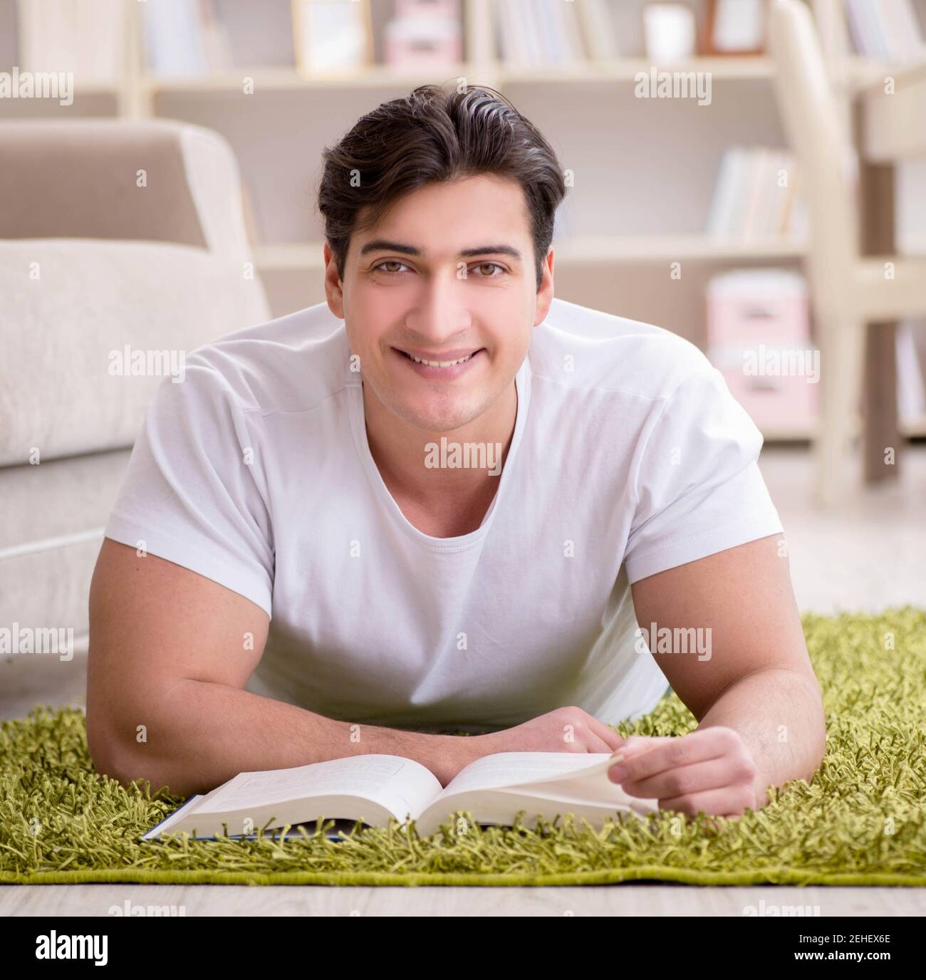The man reading book at home on floor Stock Photo - Alamy