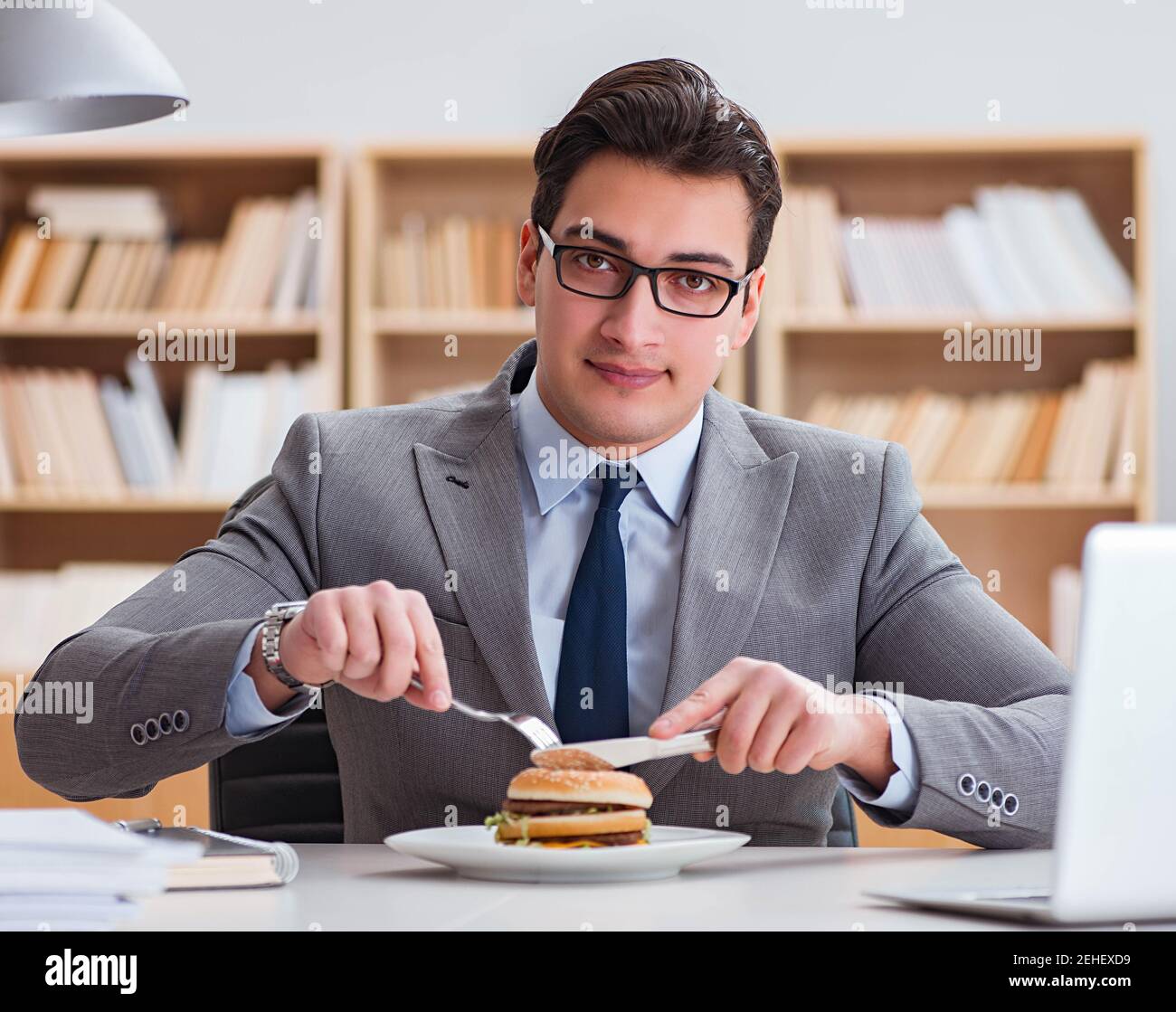 The hungry funny businessman eating junk food sandwich Stock Photo - Alamy