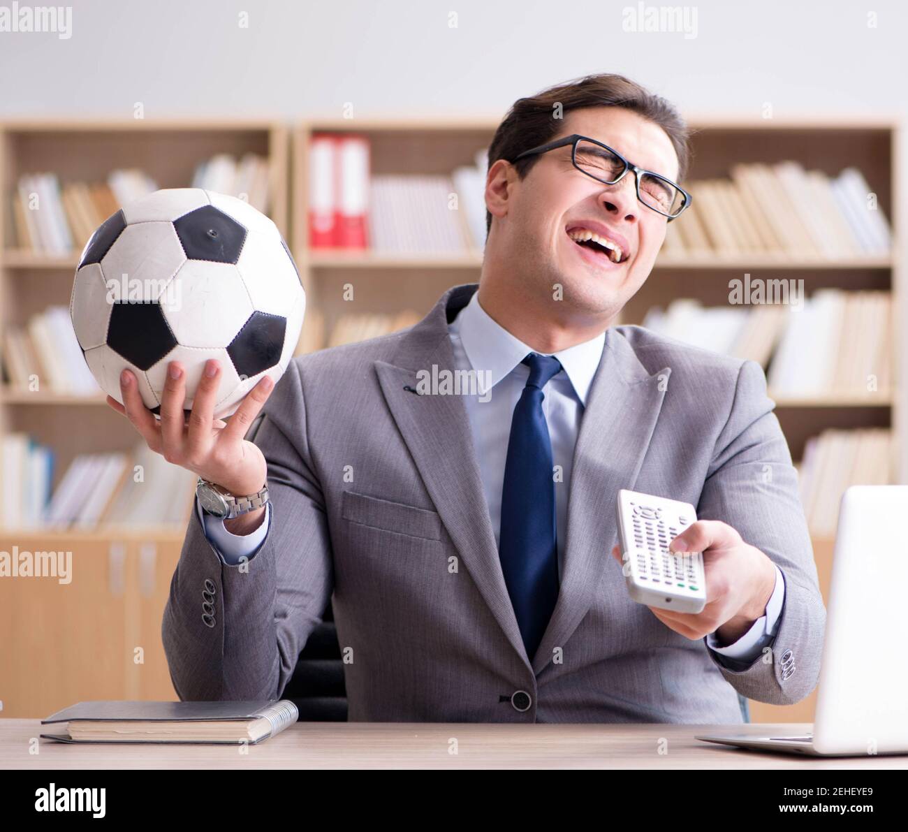 The businessman with football ball in office Stock Photo - Alamy