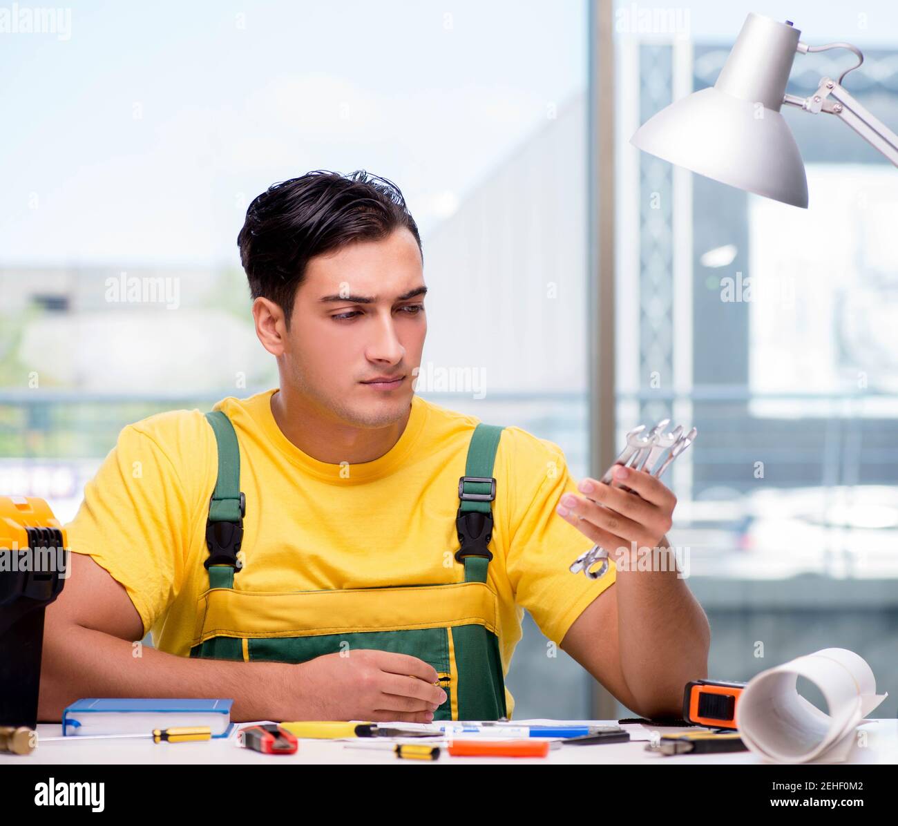 The construction worker sitting at the desk Stock Photo - Alamy