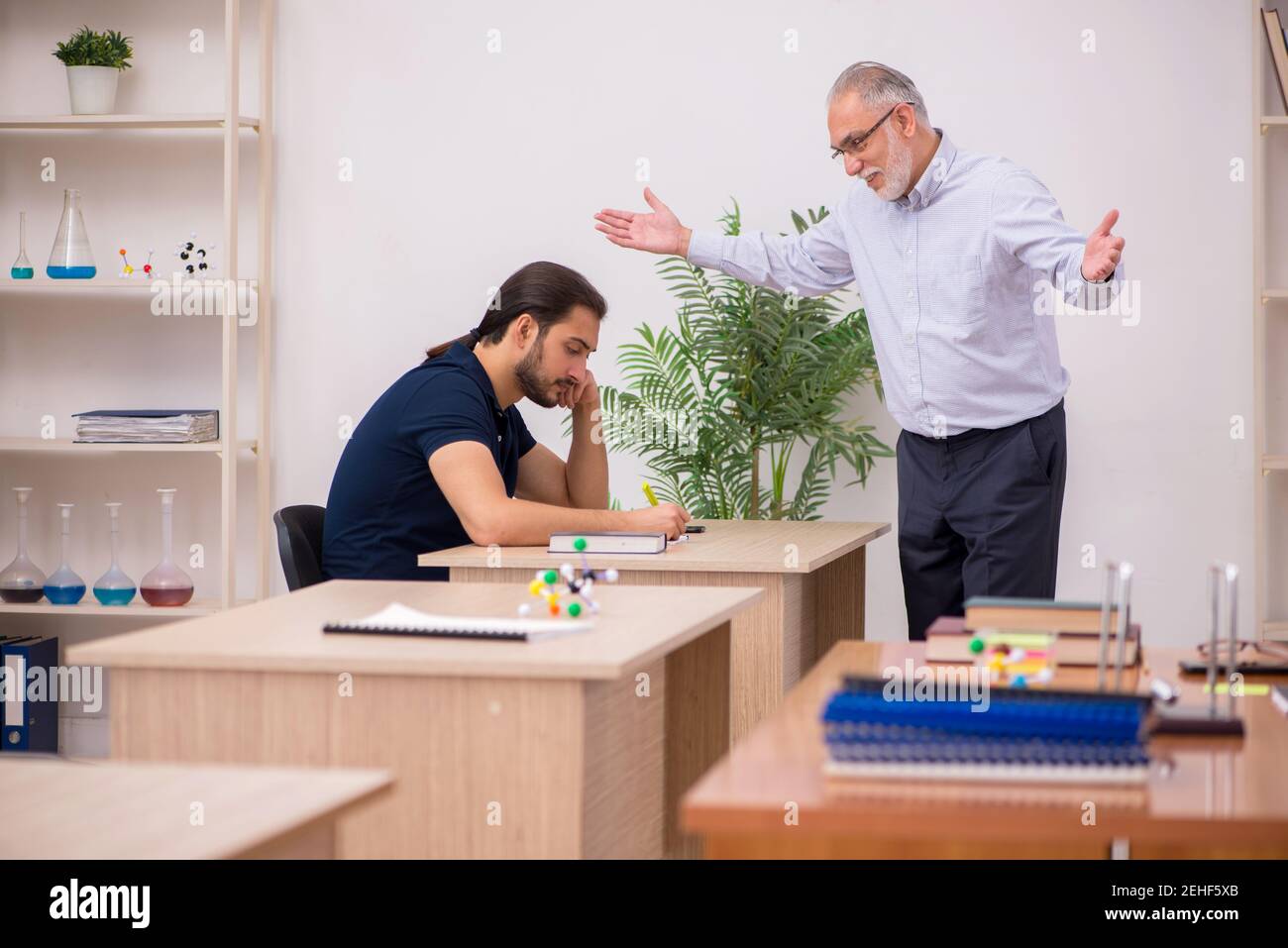 Old male teacher and young student in the classroom Stock Photo - Alamy
