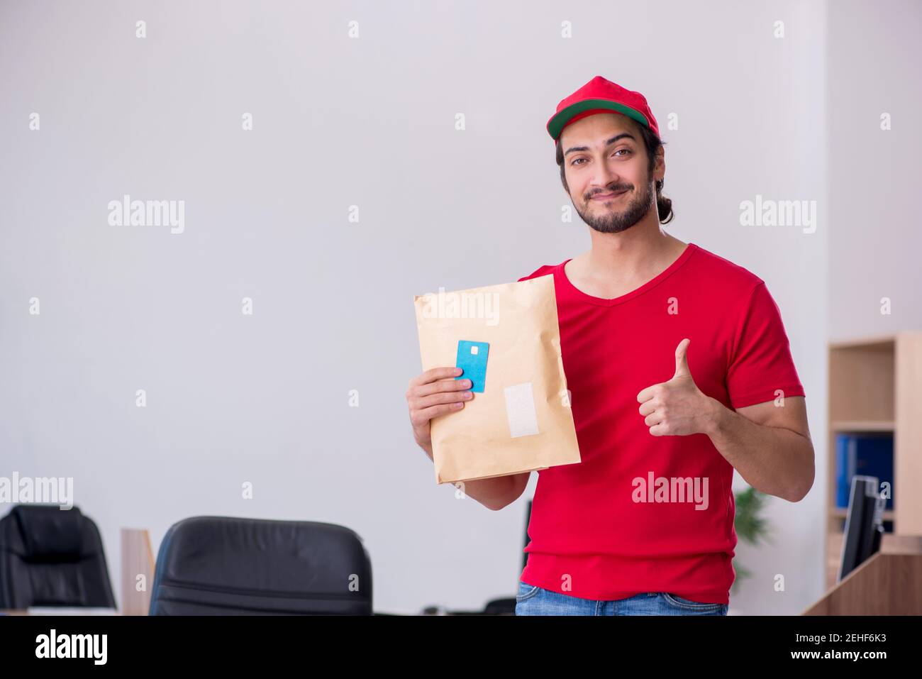 Young courier delivering post to the office Stock Photo - Alamy