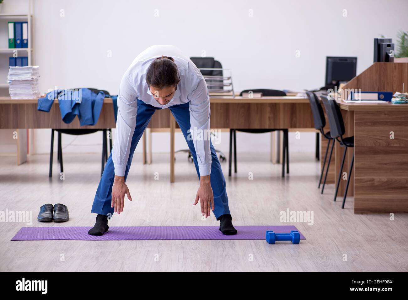 Young employee doing sport exercises during break Stock Photo - Alamy