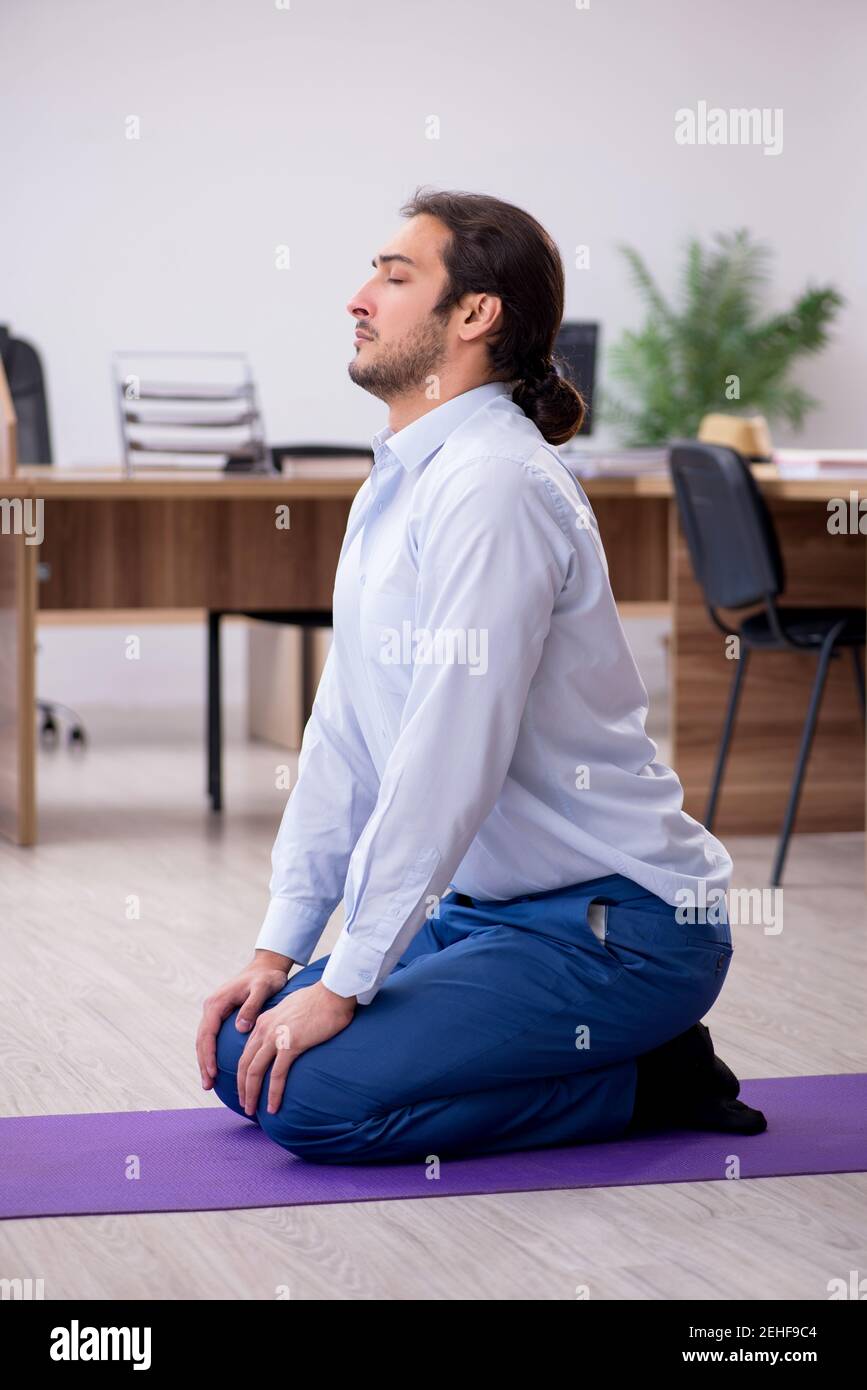 Young employee doing sport exercises during break Stock Photo - Alamy