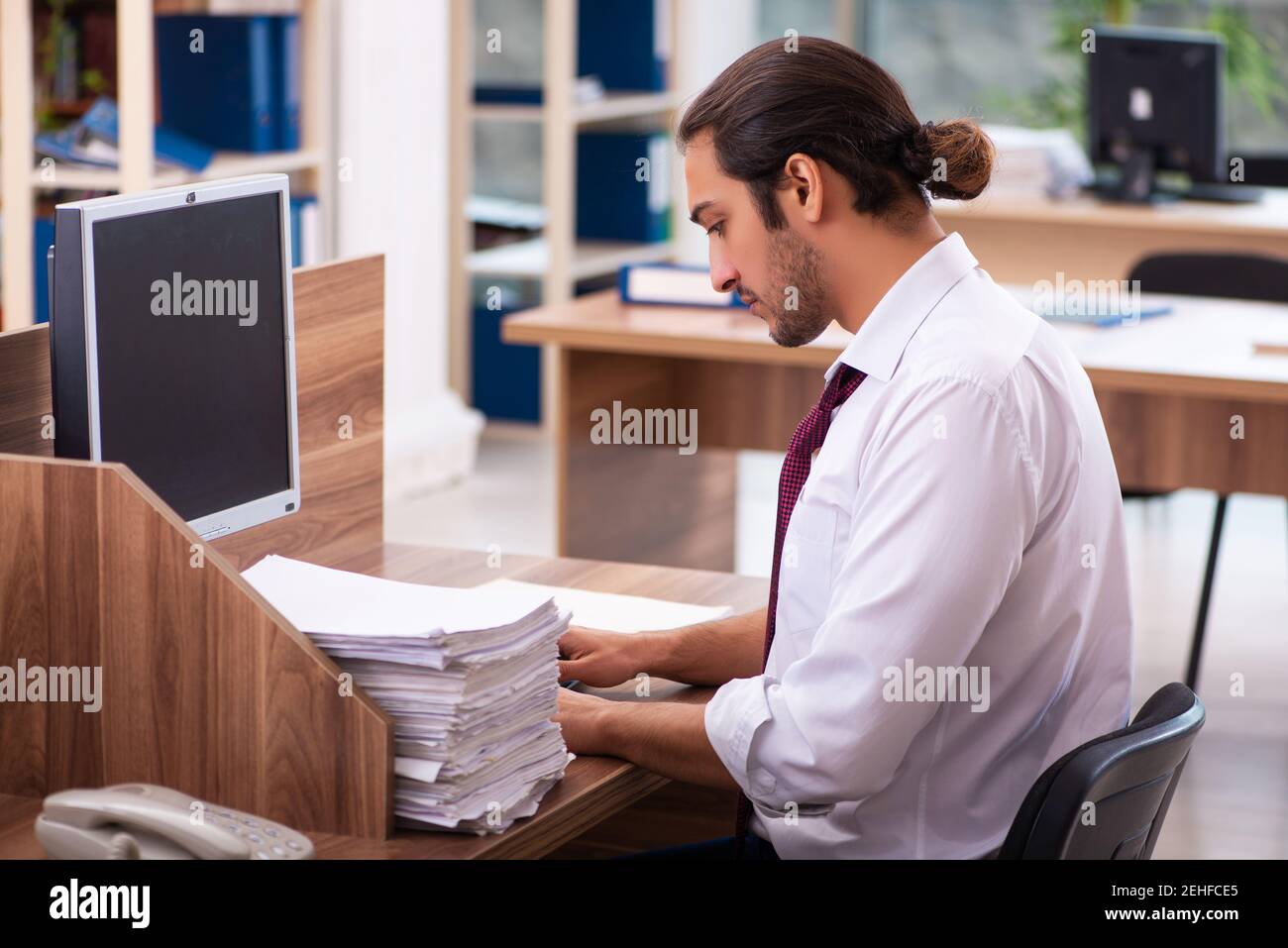 Young employee and too many work in the office Stock Photo - Alamy