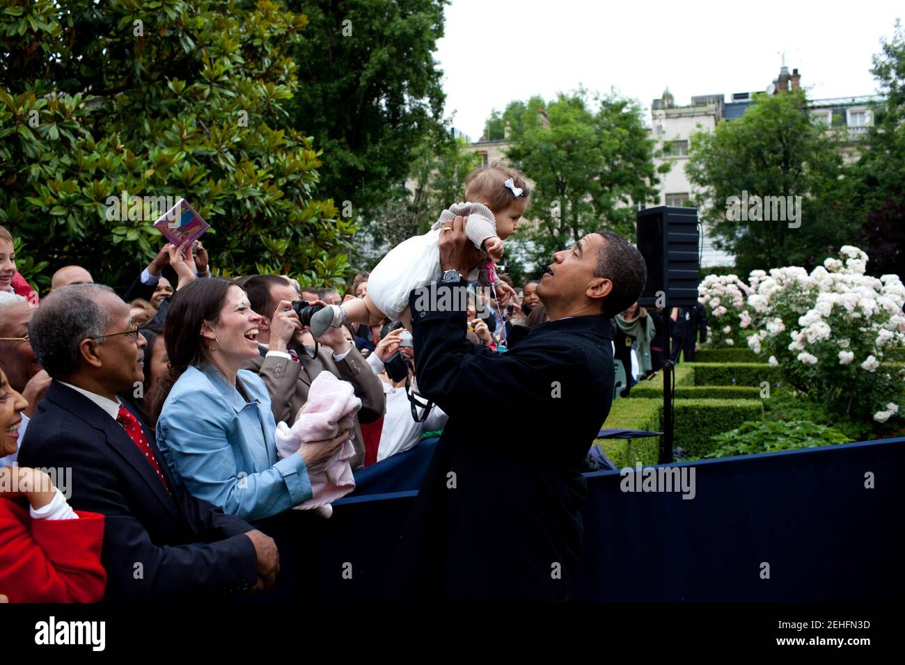 President Barack Obama lifts a baby while meeting the staff of the U.S ...