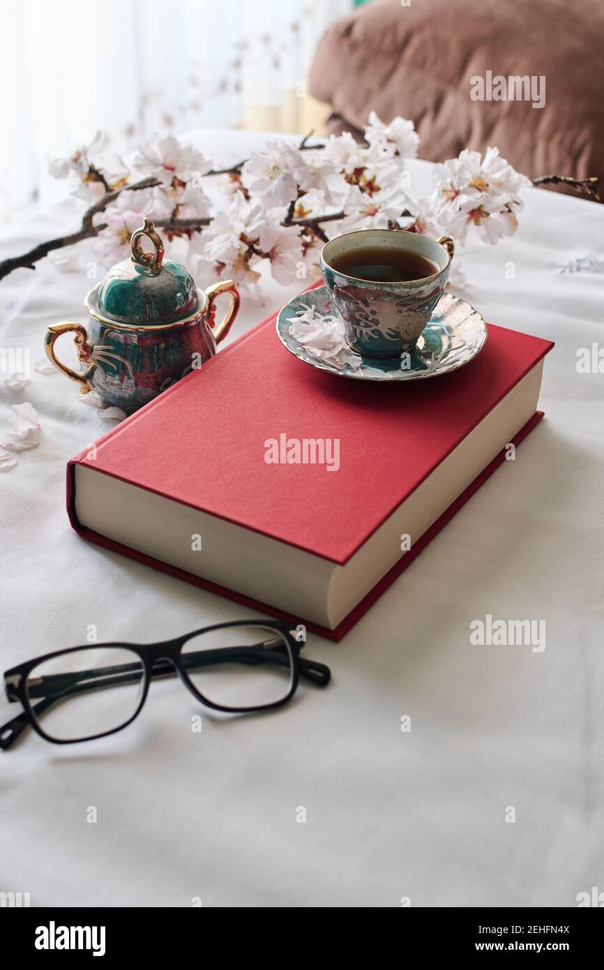 Still life of a book, coffee cups and almond blossoms. Reading concept ...