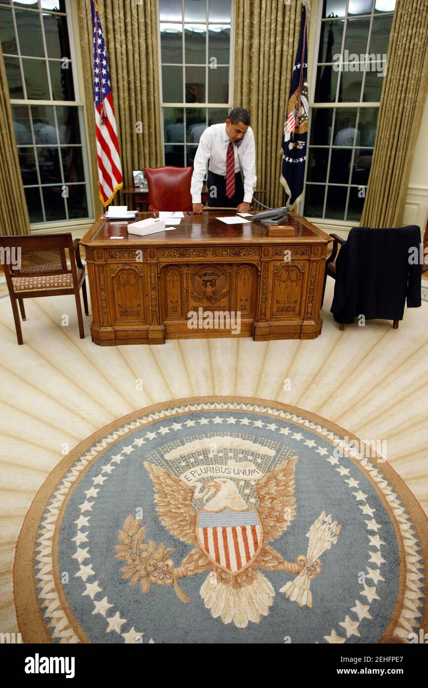 President Barack Obama makes a phone call in the Oval Office, Jan. 30 ...