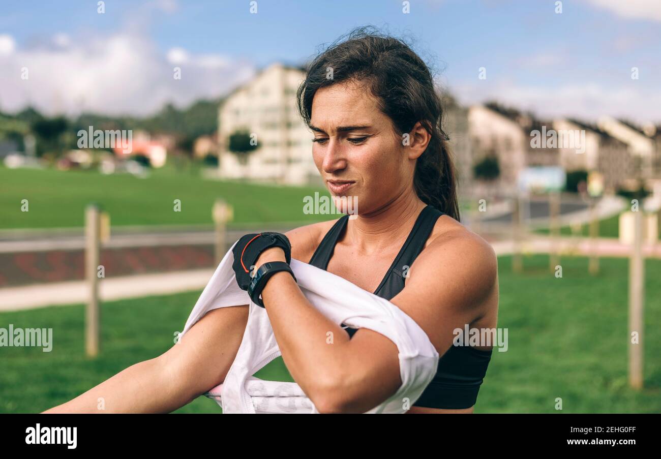 Young athlete woman taking off her shirt before training outdoors Stock ...
