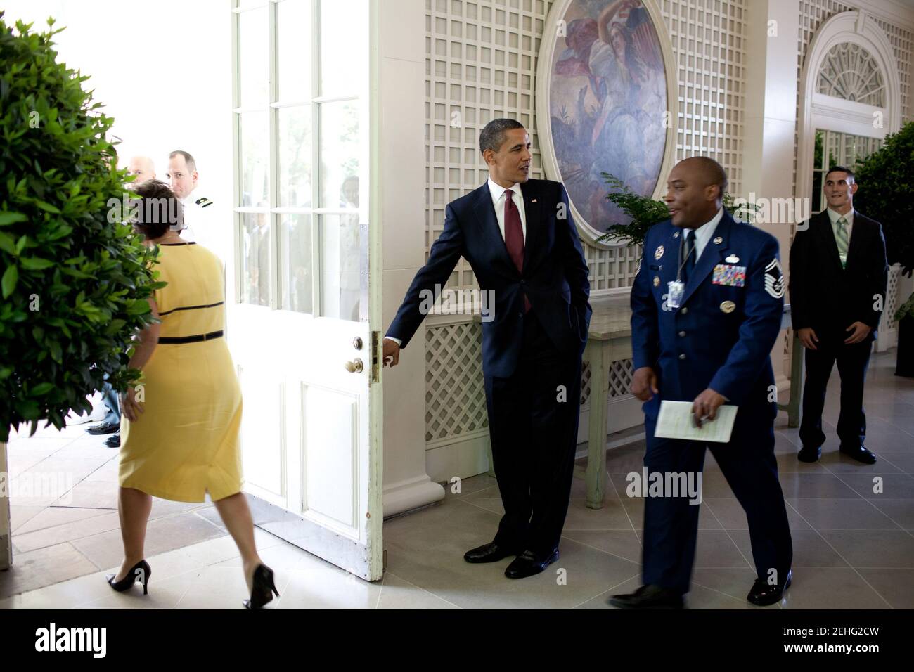 President Barack Obama holds the door for guests exiting the Palm Room ...