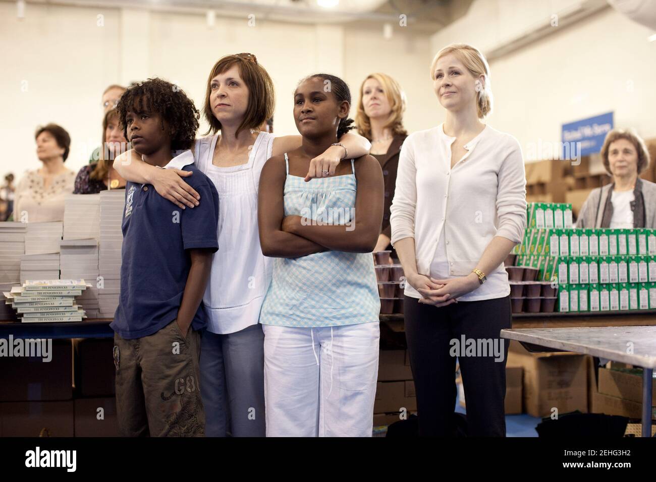 Volunteers watch President Barack Obama and First Lady Michelle Obama ...